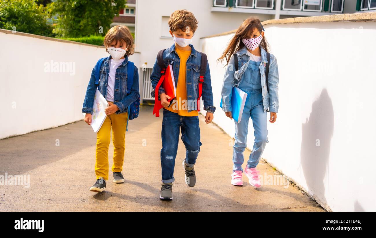 Three brothers with face masks ready to go back to school. New ...