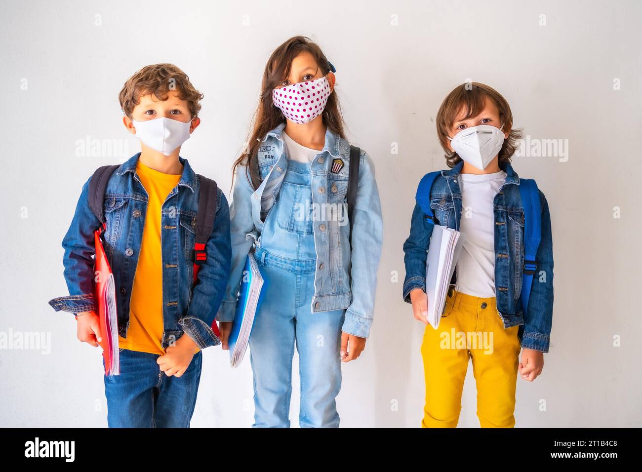 Three children with face masks ready to go back to school. New ...
