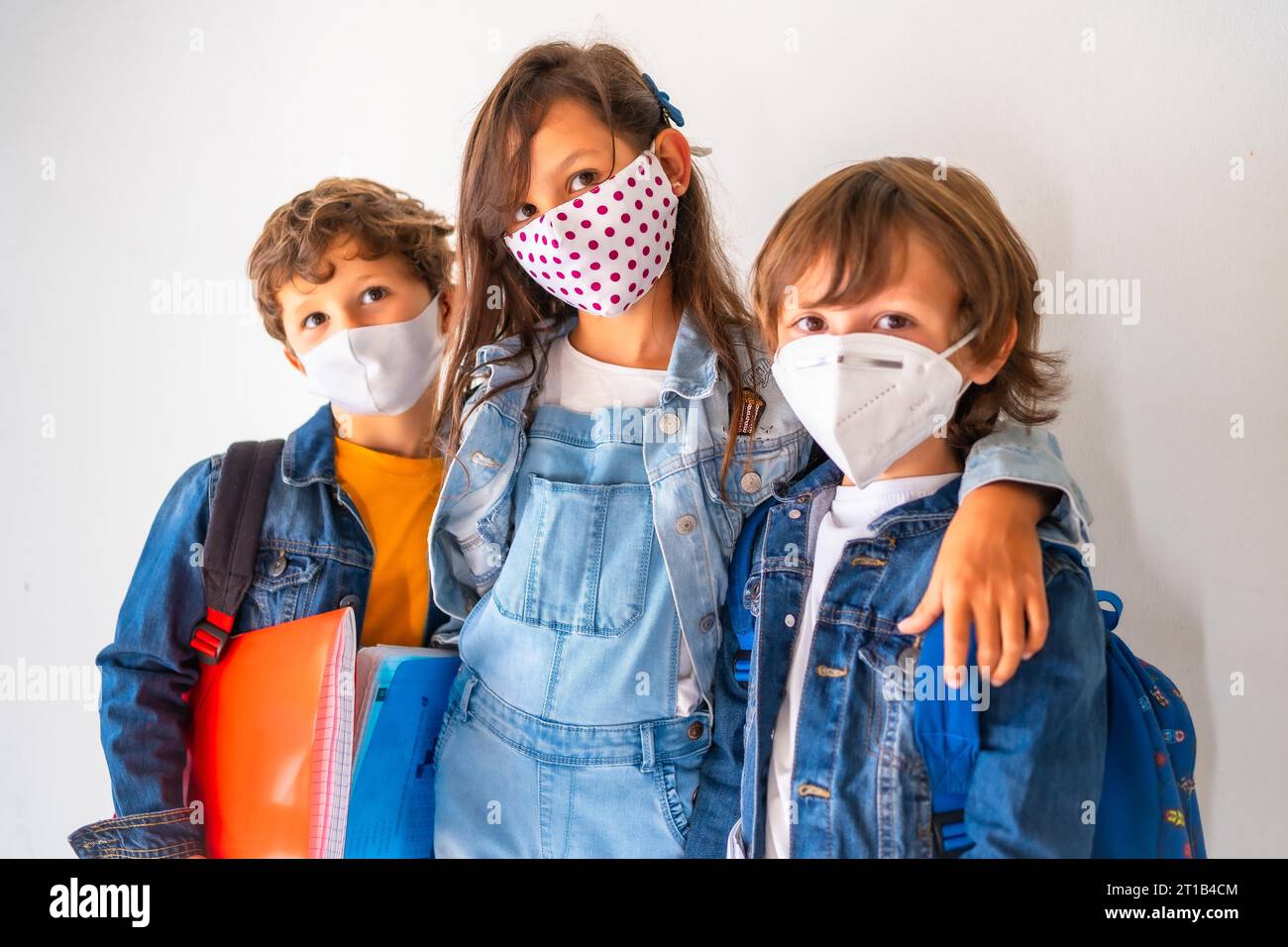 Three children with face masks ready to go back to school. New ...