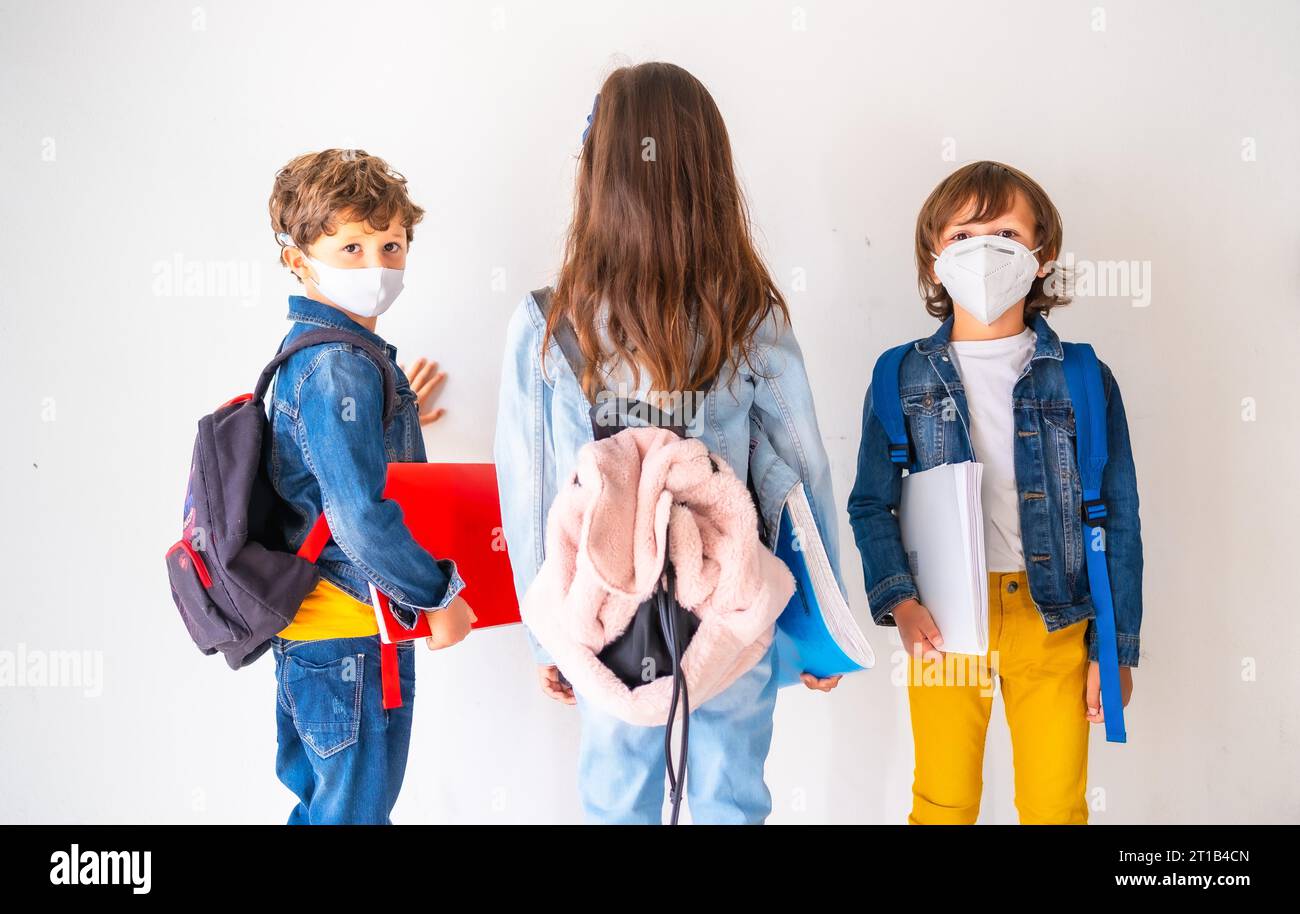 Three children with face masks ready to go back to school. New ...