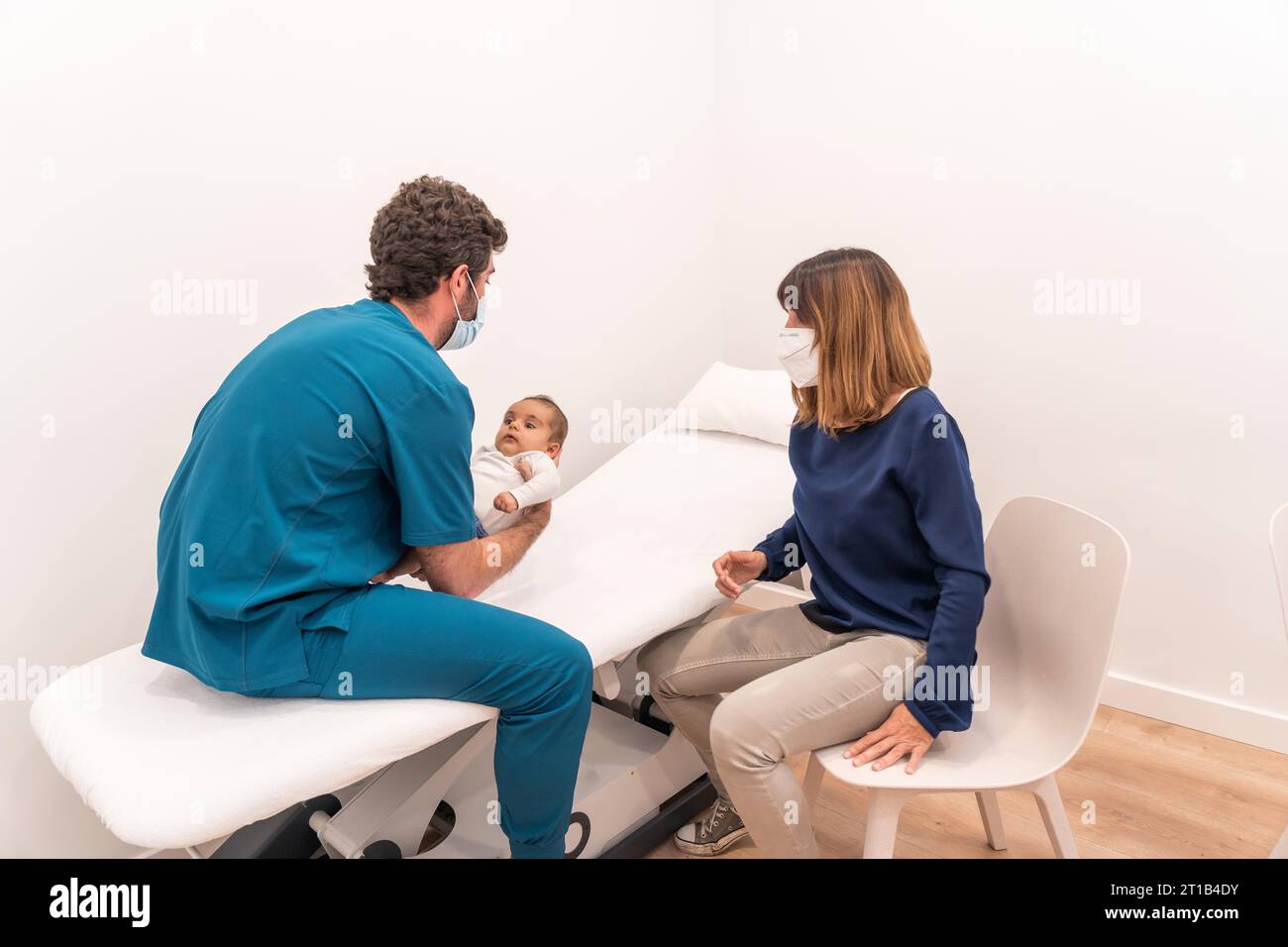 Horizontal photo with copy space of a pediatrician examines baby during ...