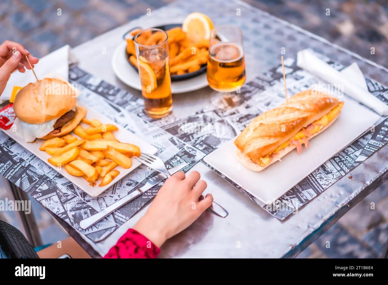 Detail of a woman eating lunch in a red dress next to a medieval castle ...