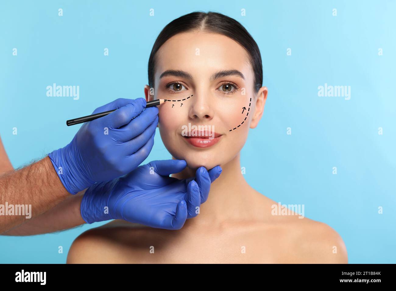 Woman preparing for cosmetic surgery, light blue background. Doctor ...