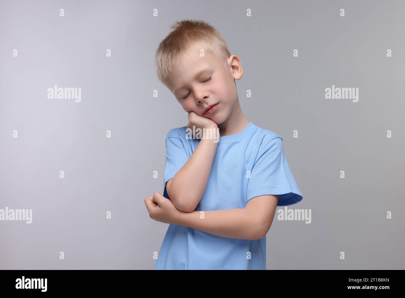 Sleepy boy on light grey background. Insomnia problem Stock Photo - Alamy