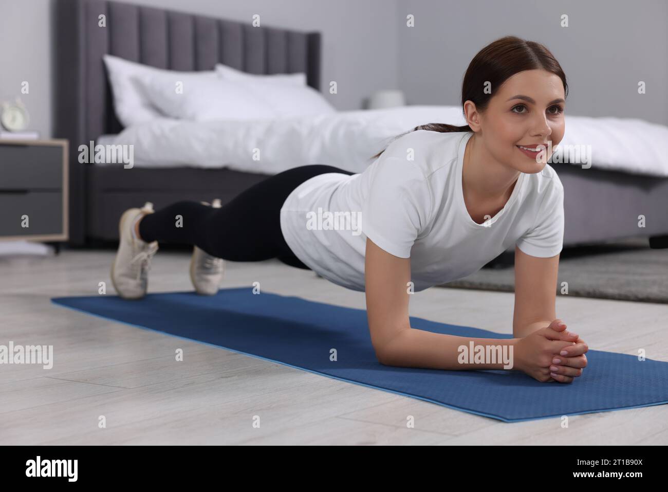 Happy woman doing plank exercise at home. Morning routine Stock Photo ...