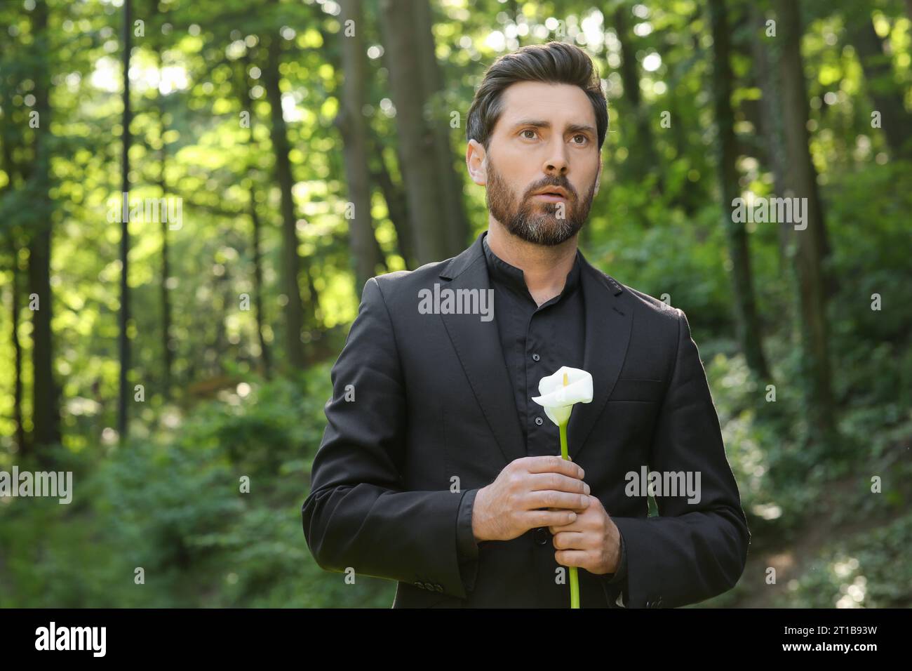 Sad man with calla lily flower outdoors. Funeral ceremony Stock Photo ...