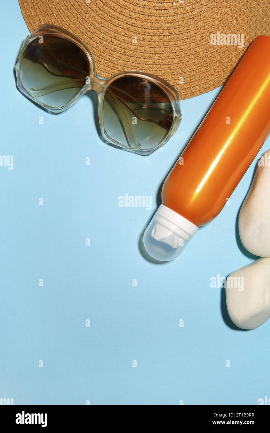 Sunscreen, stones and beach accessories on light blue background, flat ...