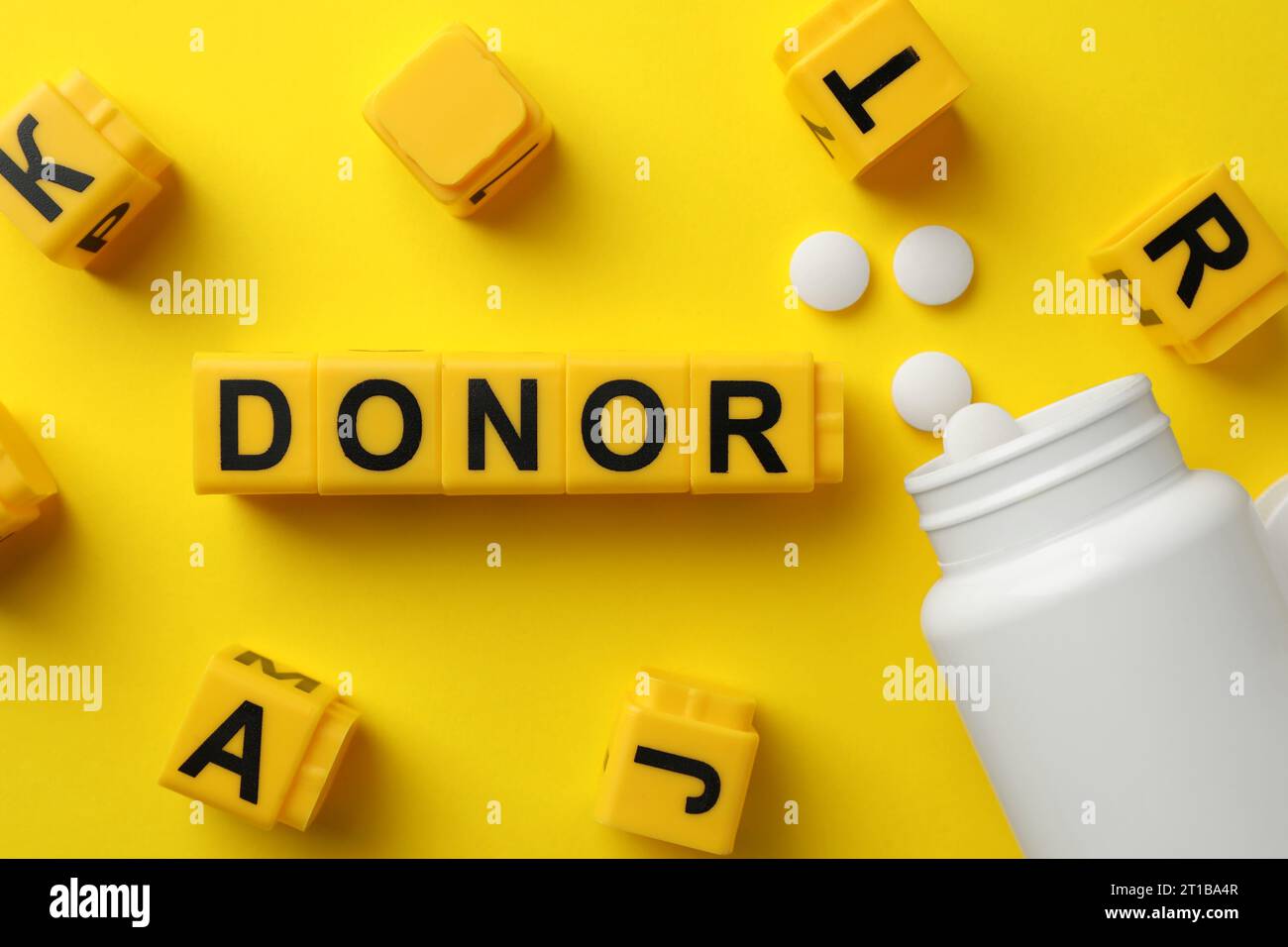 Word Donor made of cubes and pills on yellow background, flat lay Stock ...