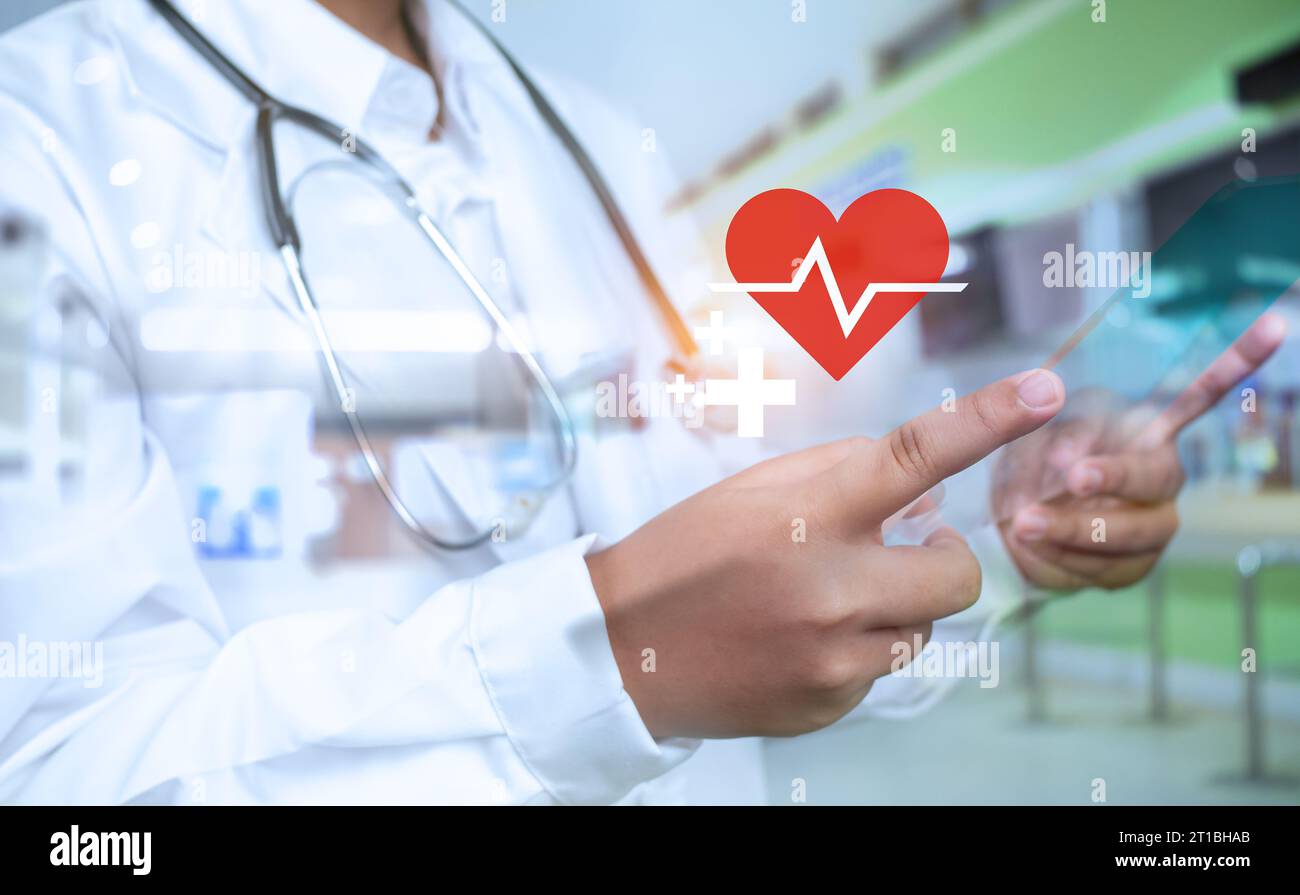 A Doctor showing a red heart at hospital office. Medical health care ...