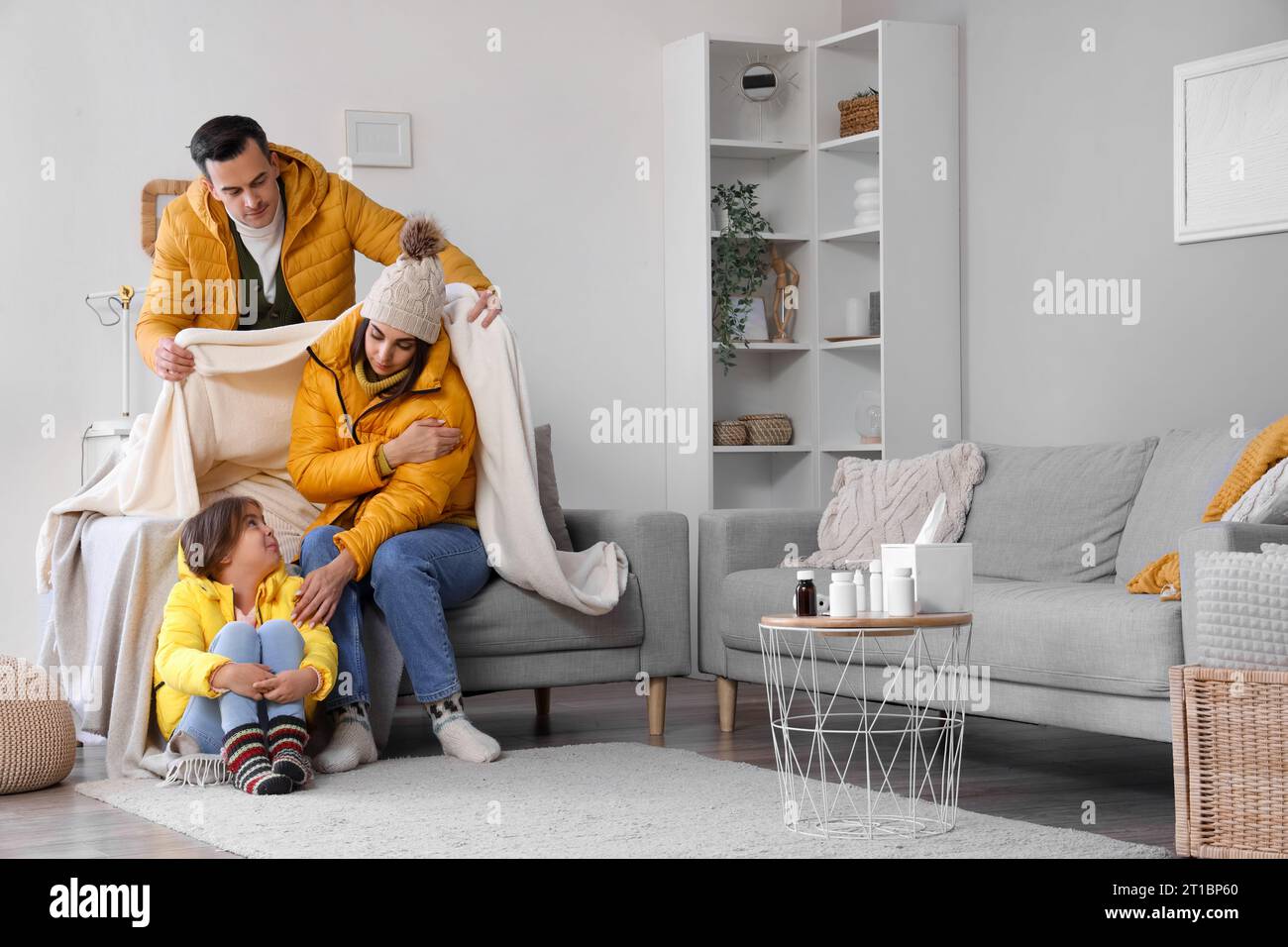 Frozen family in puffer jackets with lack of heating at home Stock ...