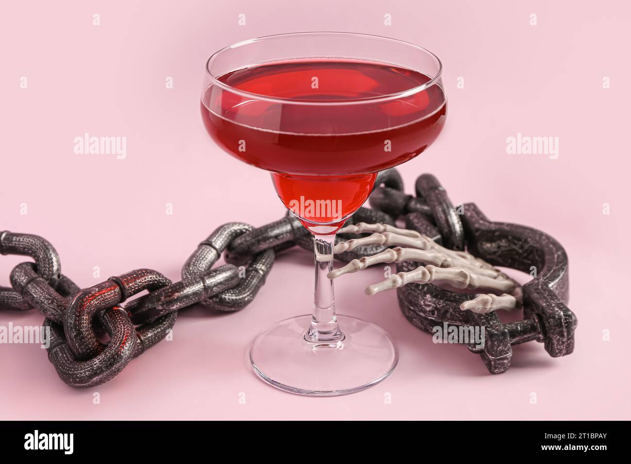Glass of delicious cocktail with skeleton hand and chain for Halloween ...