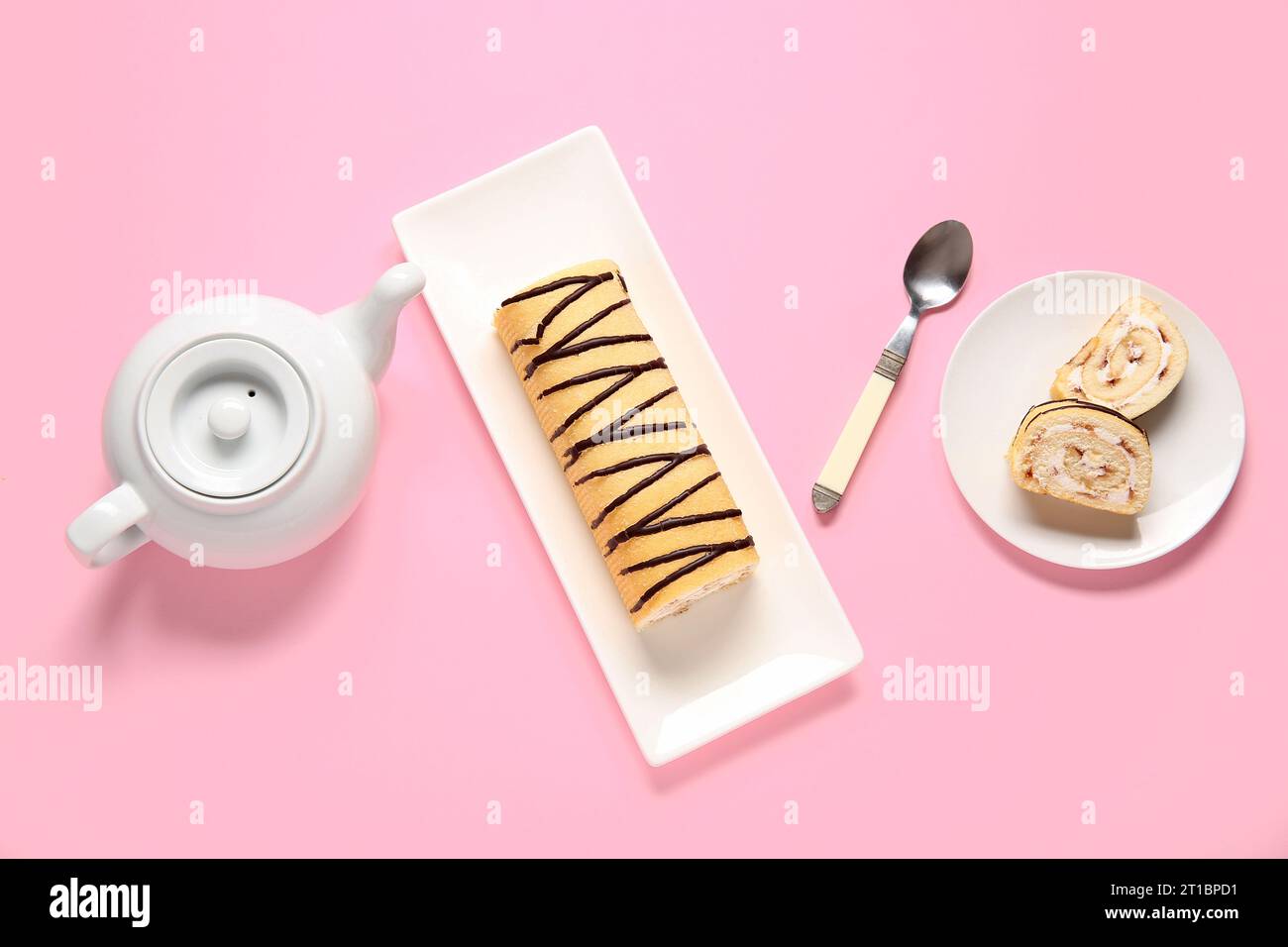 Plates with sweet sponge cake roll and tea pot on pink background Stock ...