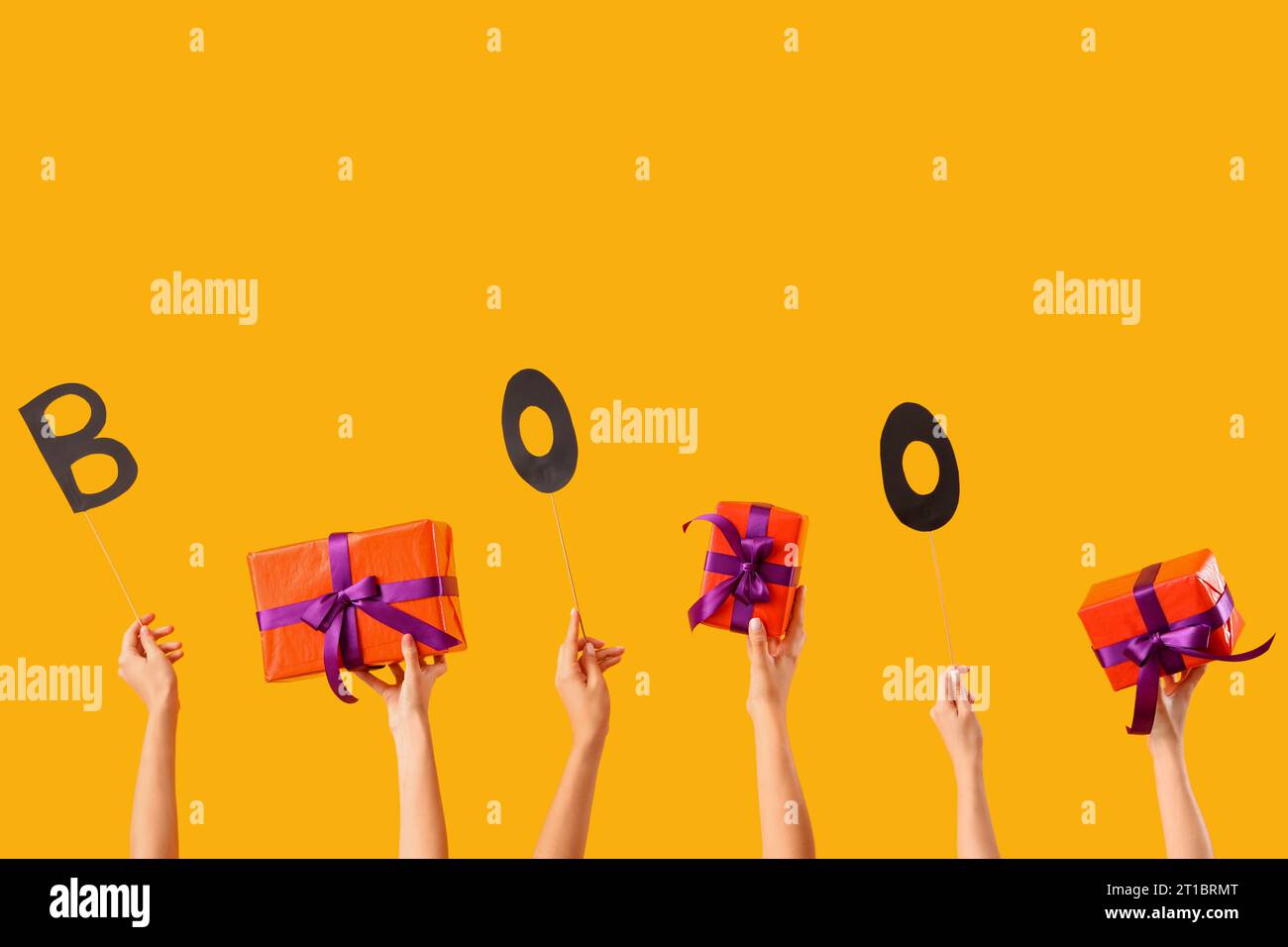 Women with Halloween gifts and word BOO on yellow background Stock ...