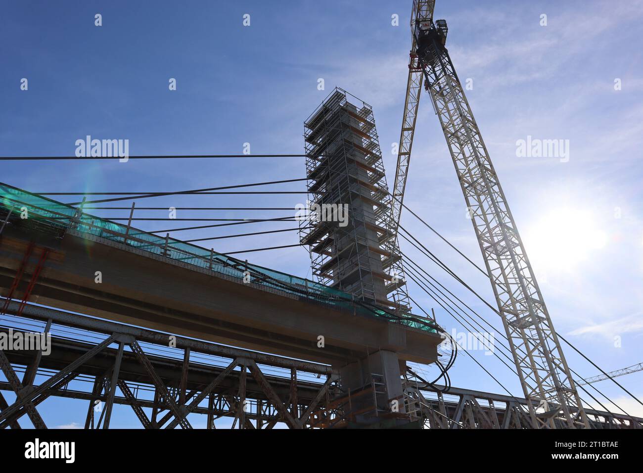 A busy construction site with multiple large cranes working in tandem ...