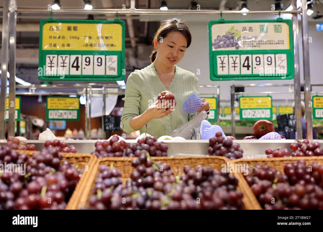 BINZHOU, CHINA - OCTOBER 13, 2023 - A consumer shops at a supermarket ...