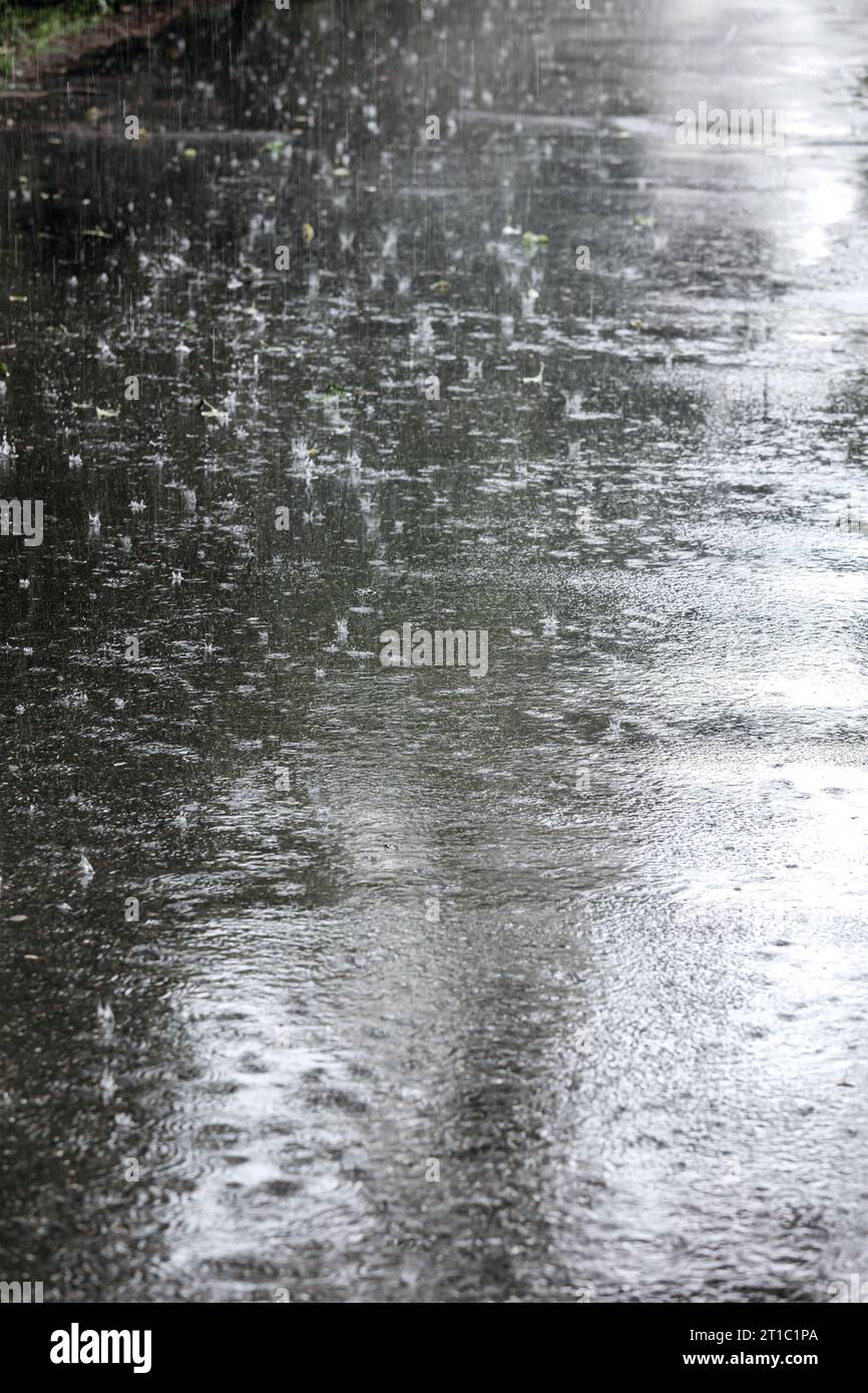 flooded sidewalk during heavy rain with raindrops splashes on water ...