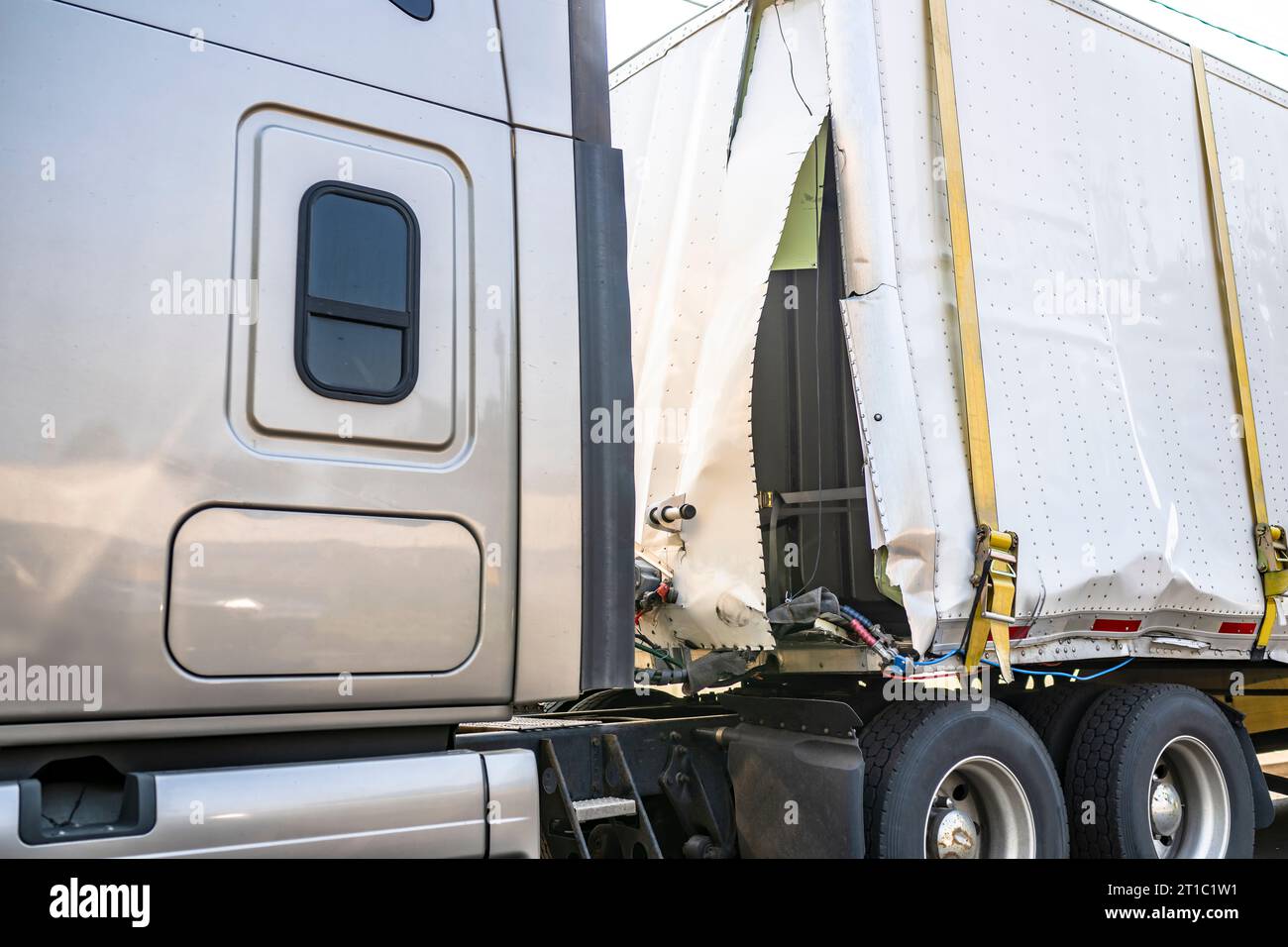 Beige industrial grade big rig semi truck tractor with broken dry van ...