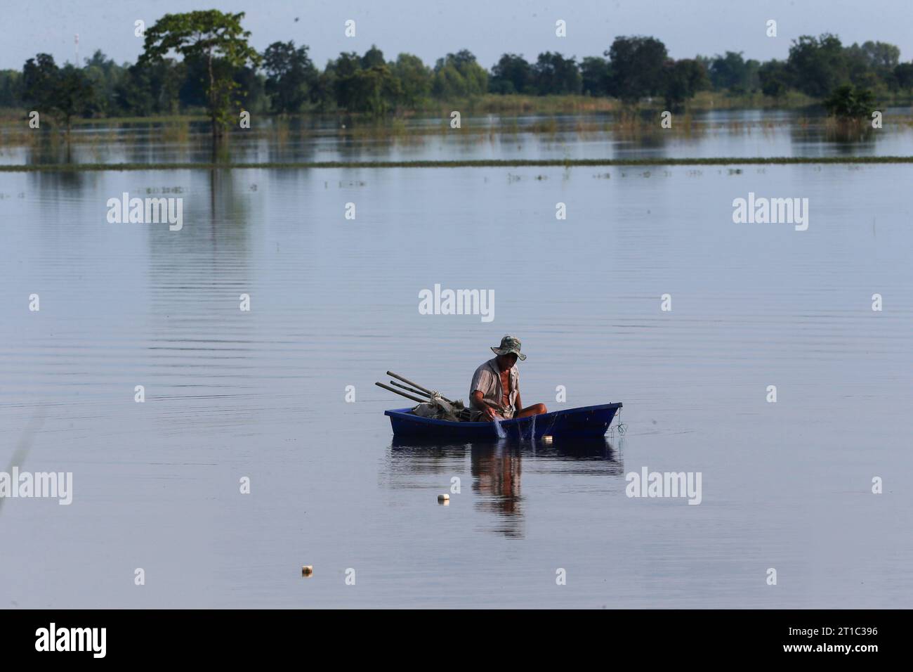 Nakhon Sawan, Thailand. 12th Oct, 2023. A villager rows a boat along a flooded rice field, in ...