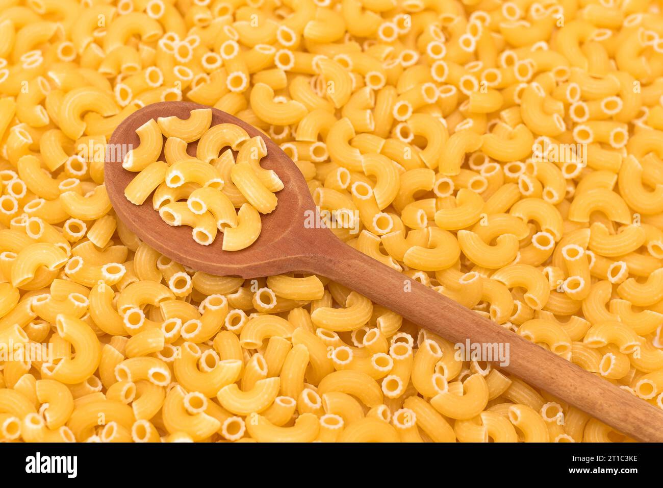 Uncooked Chifferi Rigati Pasta Background with Wooden Spoon. Fat and ...