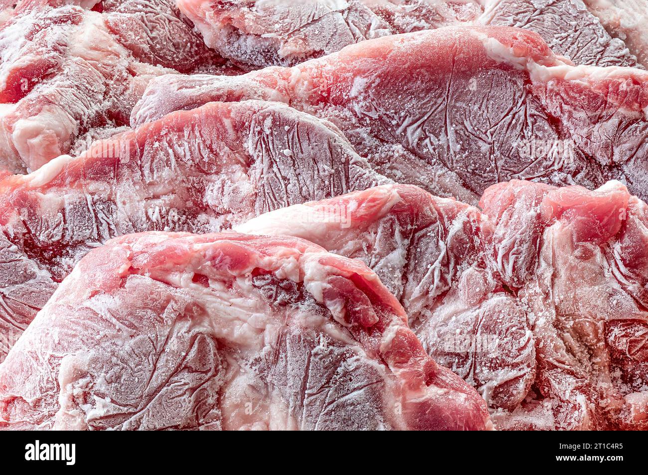 Raw frozen meat pieces. raw pork chops close-up texture. Fast freeze ...