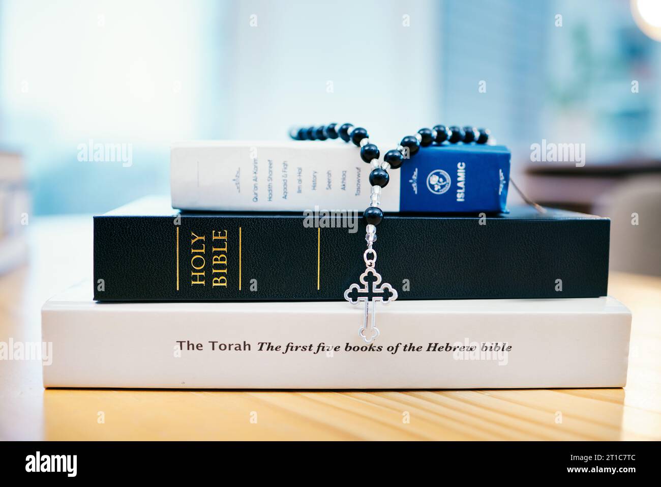 Books, stack and closeup on table for faith, Abrahamic religion or ...