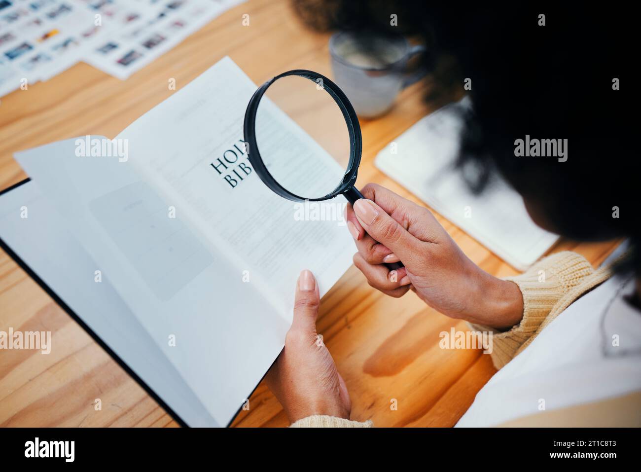 Bible, research and person with magnifying glass to study religion ...
