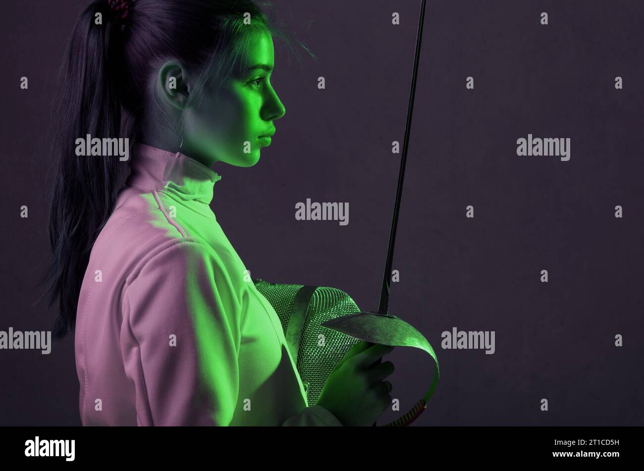 Young woman fencer profile portrait with fencing equipment holding ...