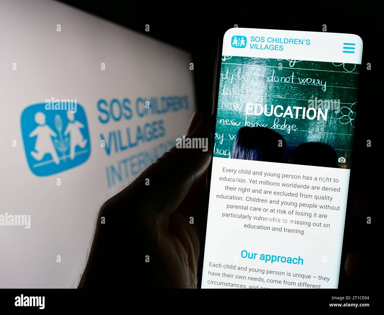 Person holding cellphone with websote of charity organization SOS ...