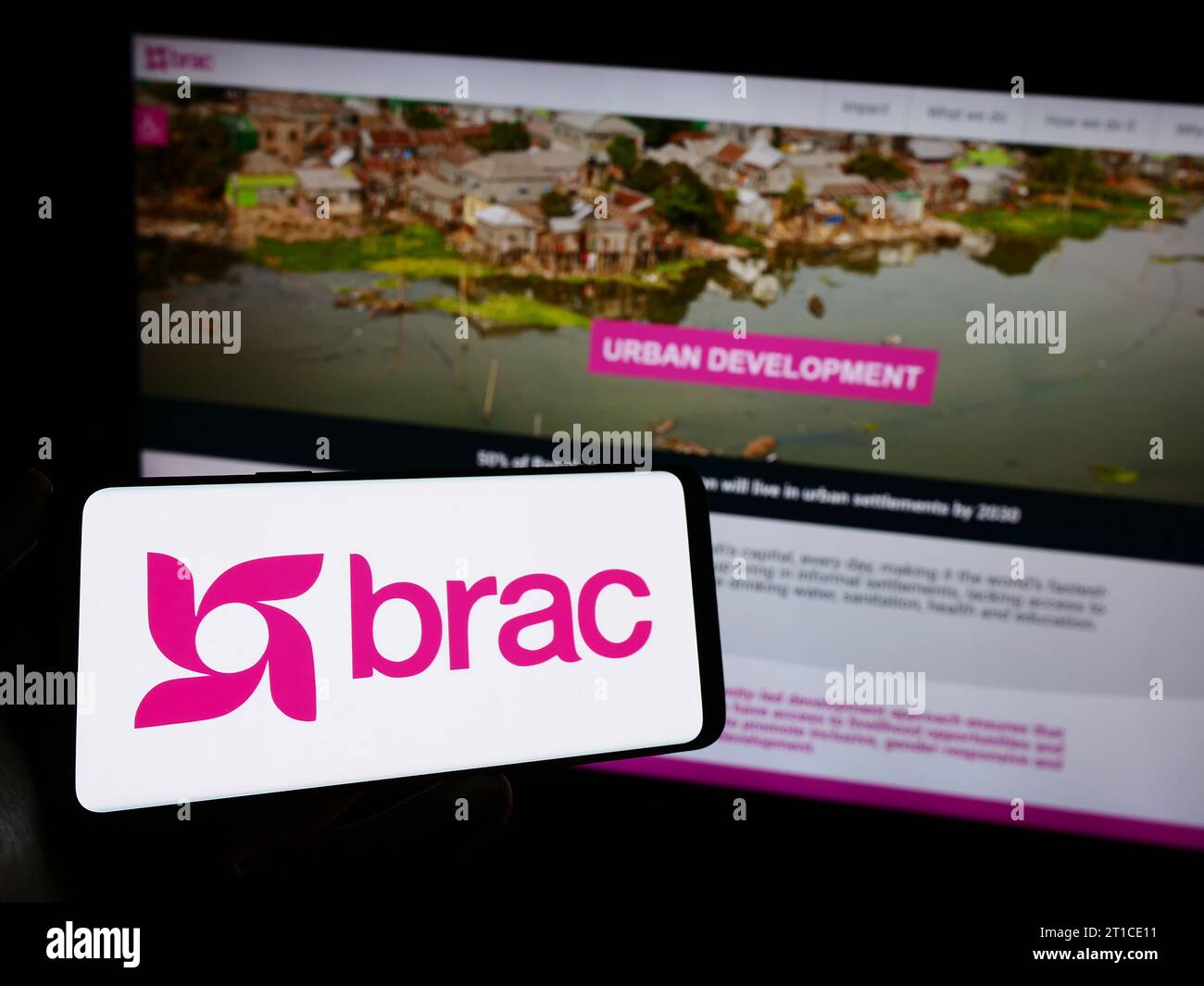 Person holding mobile phone with logo of international development organization BRAC in front of ...