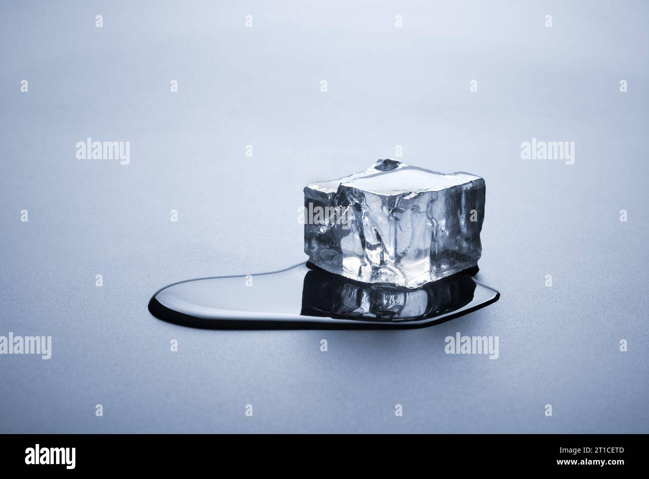 one melted ice cube with water puddle Stock Photo - Alamy