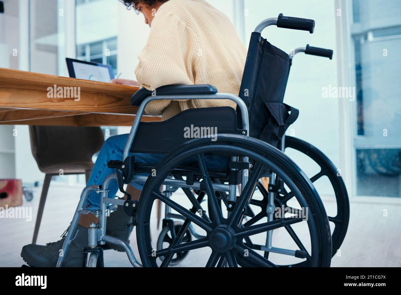 Business, desk and worker in wheelchair in office, working on project ...
