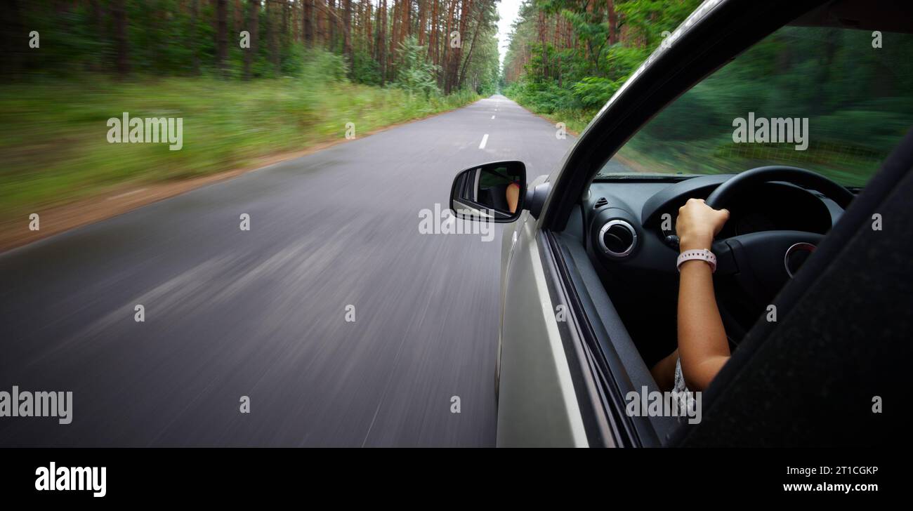 Young beautiful woman driving car in the forest - rear view Stock Photo ...