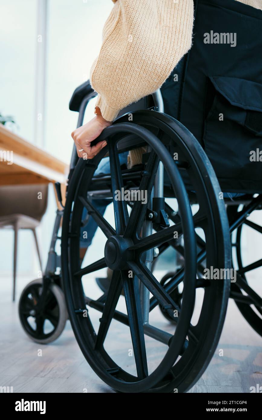 Hand, wheelchair and person with a disability closeup in a home for ...