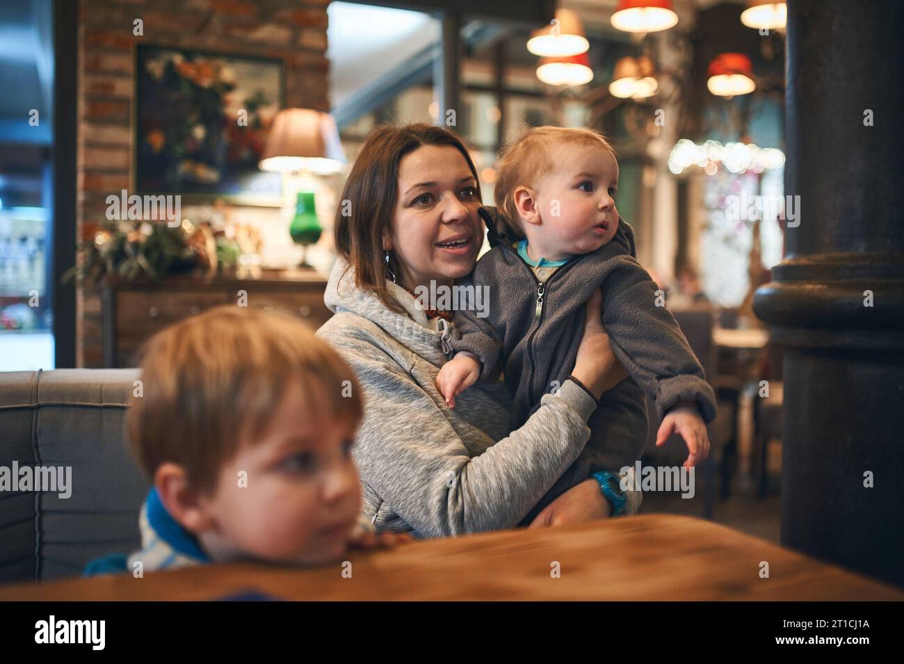 mother with two kids in cafe waiting for order Stock Photo - Alamy