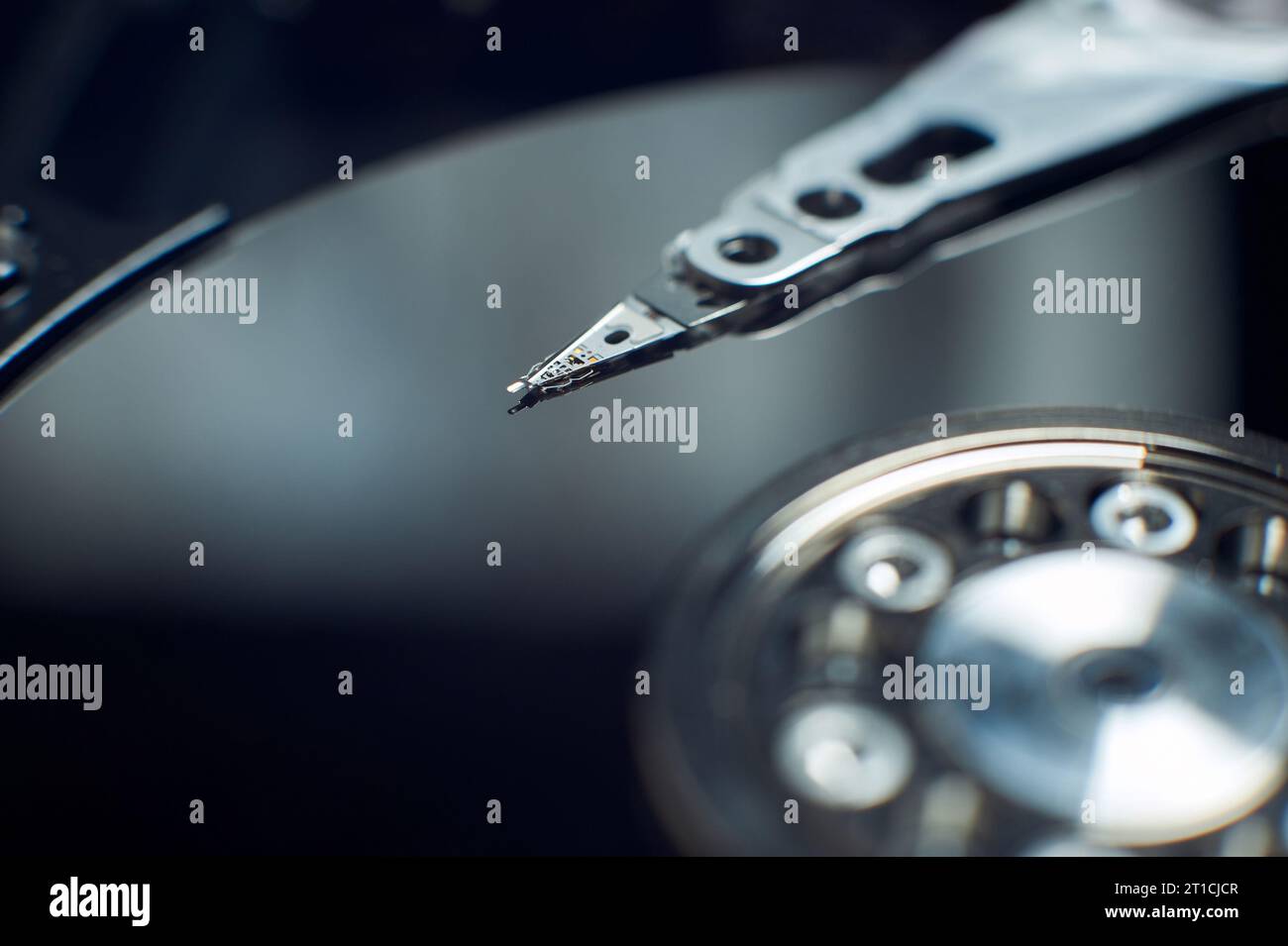 Disassembled hard disc. Read head, magnetic disk and spindle close-up ...