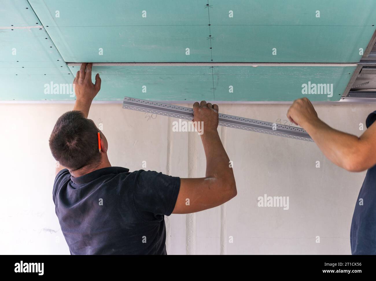 Workers fitting panel into frame of ceiling Stock Photo - Alamy