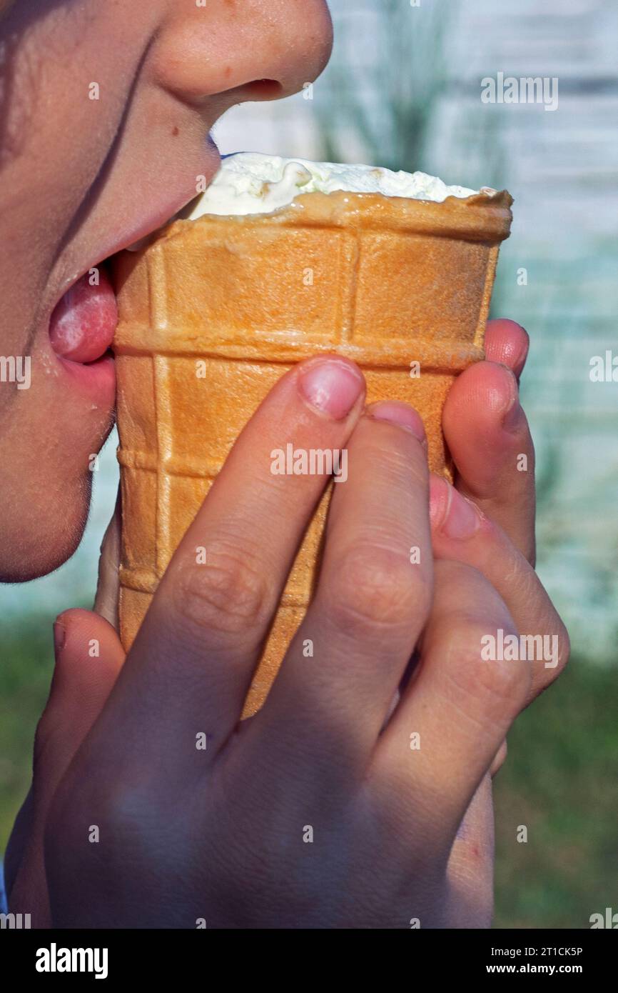 child bites a waffle cup with pistachio ice cream in nature Stock Photo ...