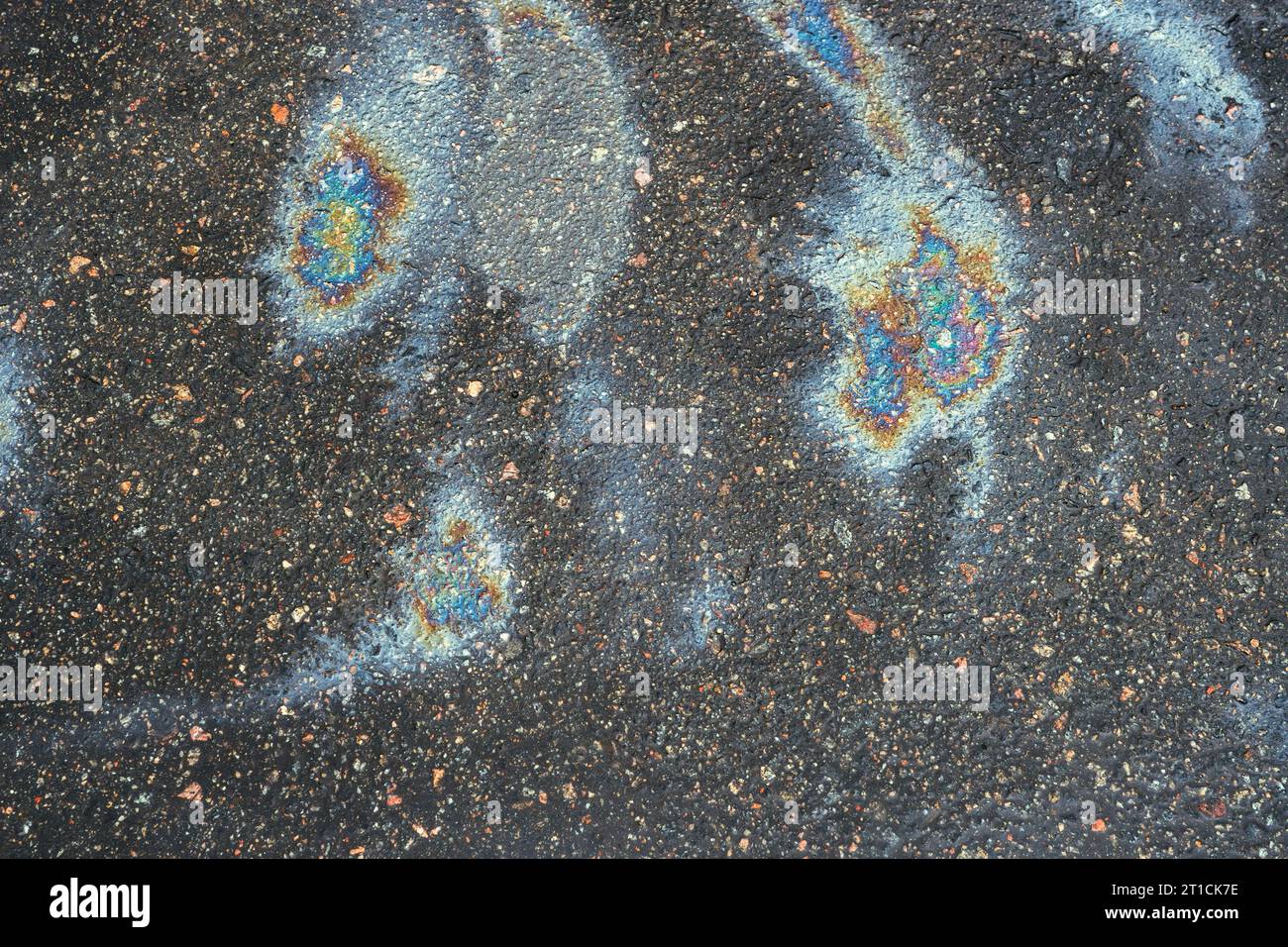Iridescent spot of gasoline on pavement. Stains of gasoline pollute the ...
