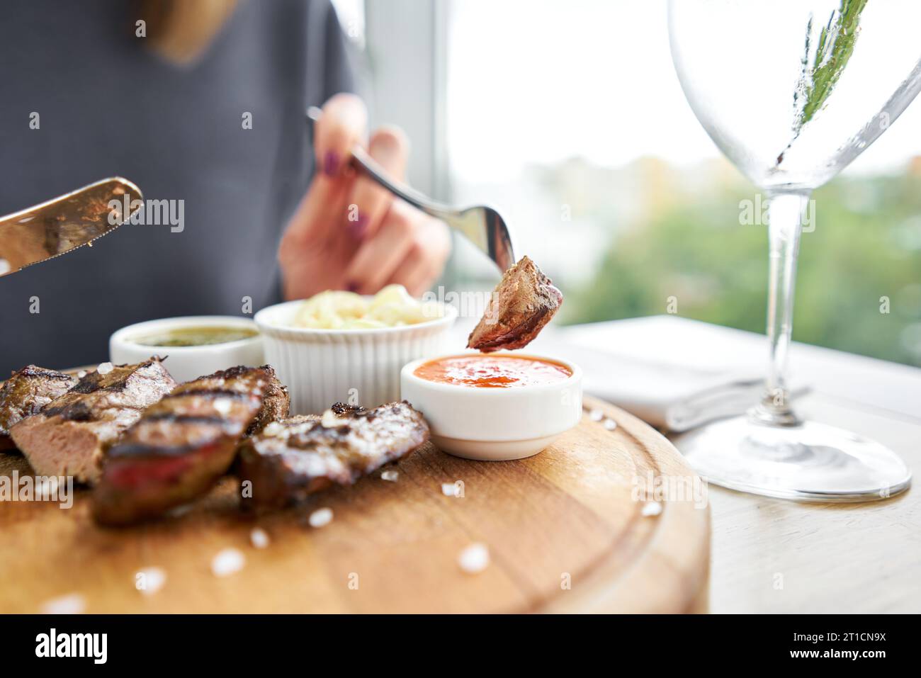 Lunch in a restaurant, a woman eats Pieces of liver cooked on the grill ...