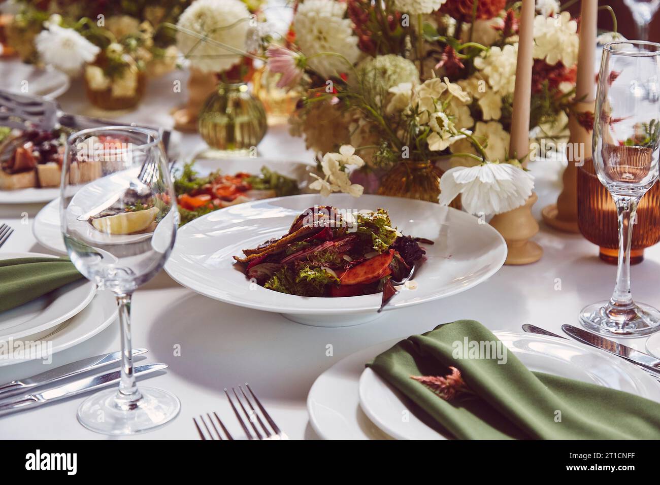 Aesthetic stylish autumn table setting, arranged flowers and candles ...