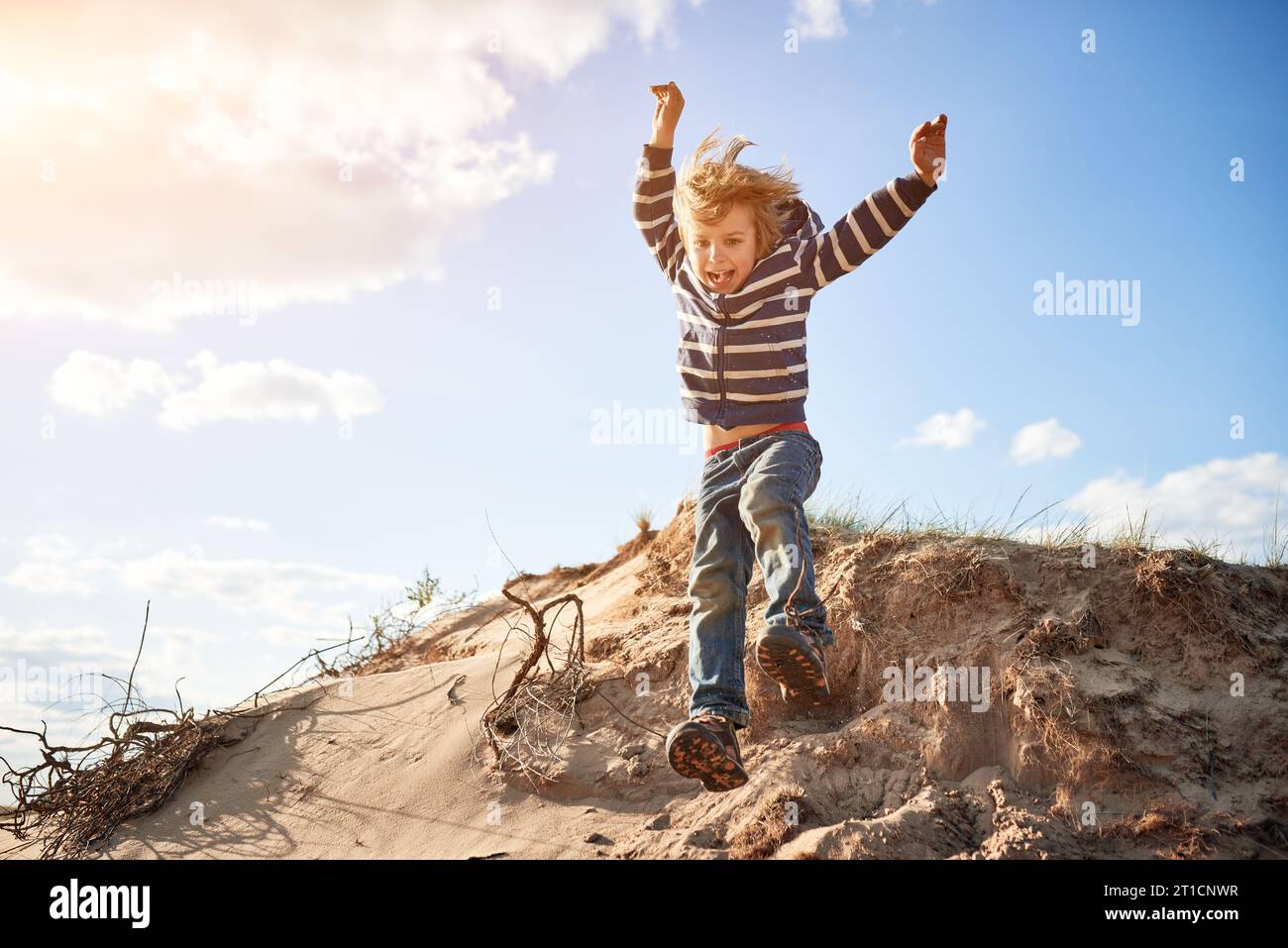 Happy boy jumping on sand at sunny day Stock Photo - Alamy