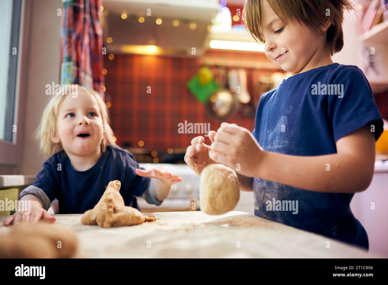 Funny boys are preparing the dough, bake cookies in the kitchen at home ...