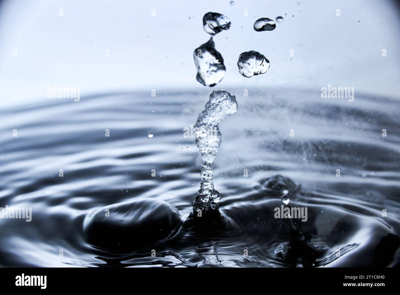 Boiling water splash with steam on blue background closeup Stock Photo ...