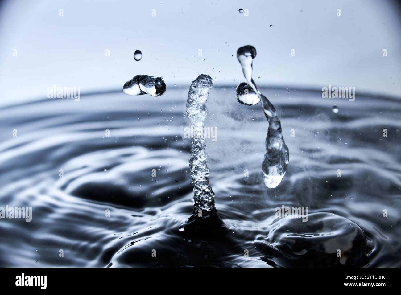 Boiling water splash with steam on blue background closeup Stock Photo ...