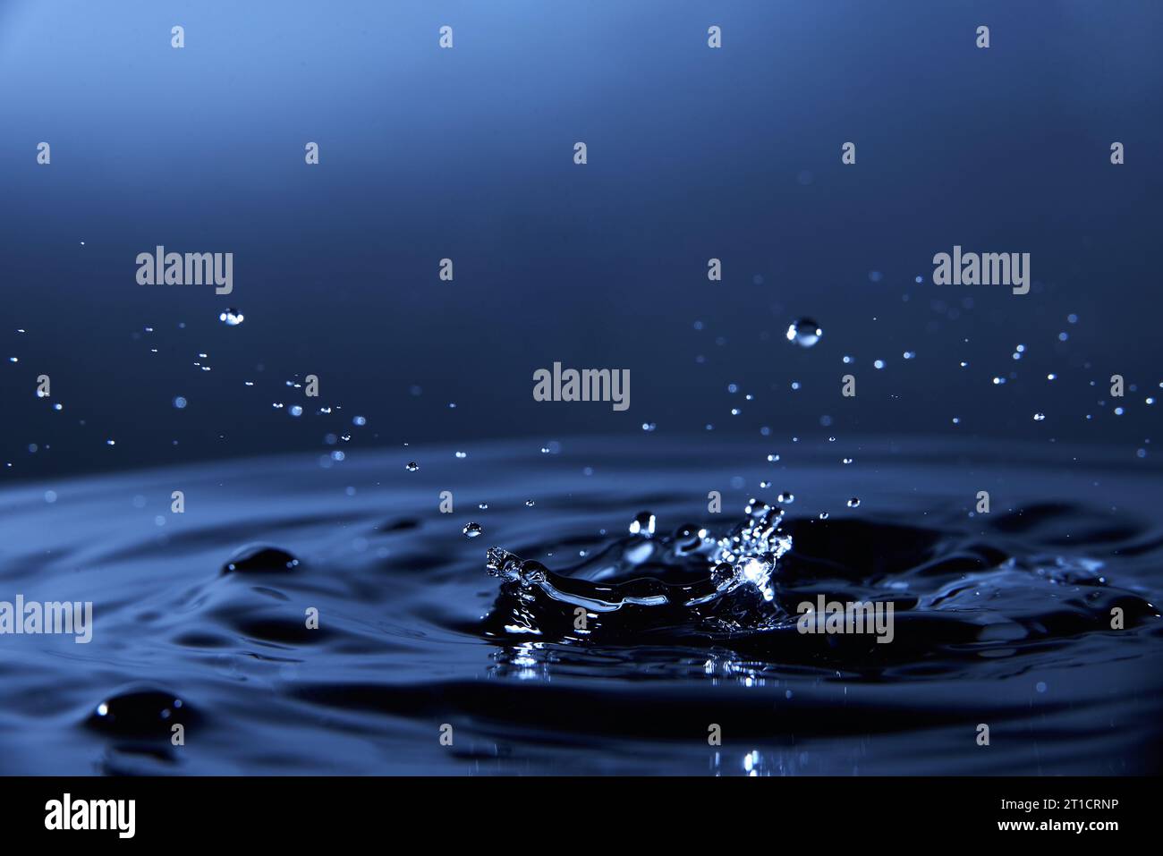 falling drop of water closeup on a dark blue background Stock Photo - Alamy