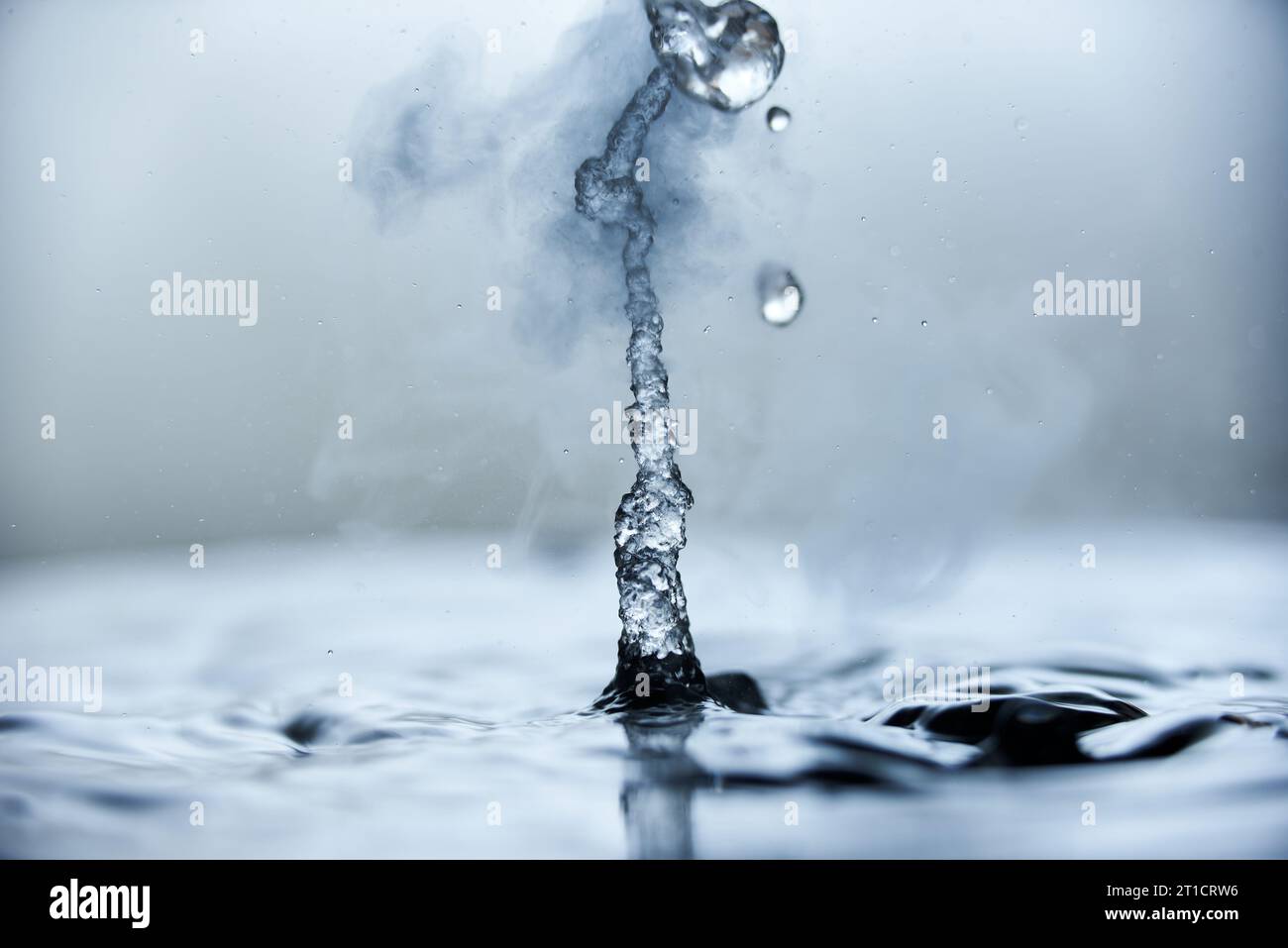 Boiling water splash with steam on blue background closeup Stock Photo ...