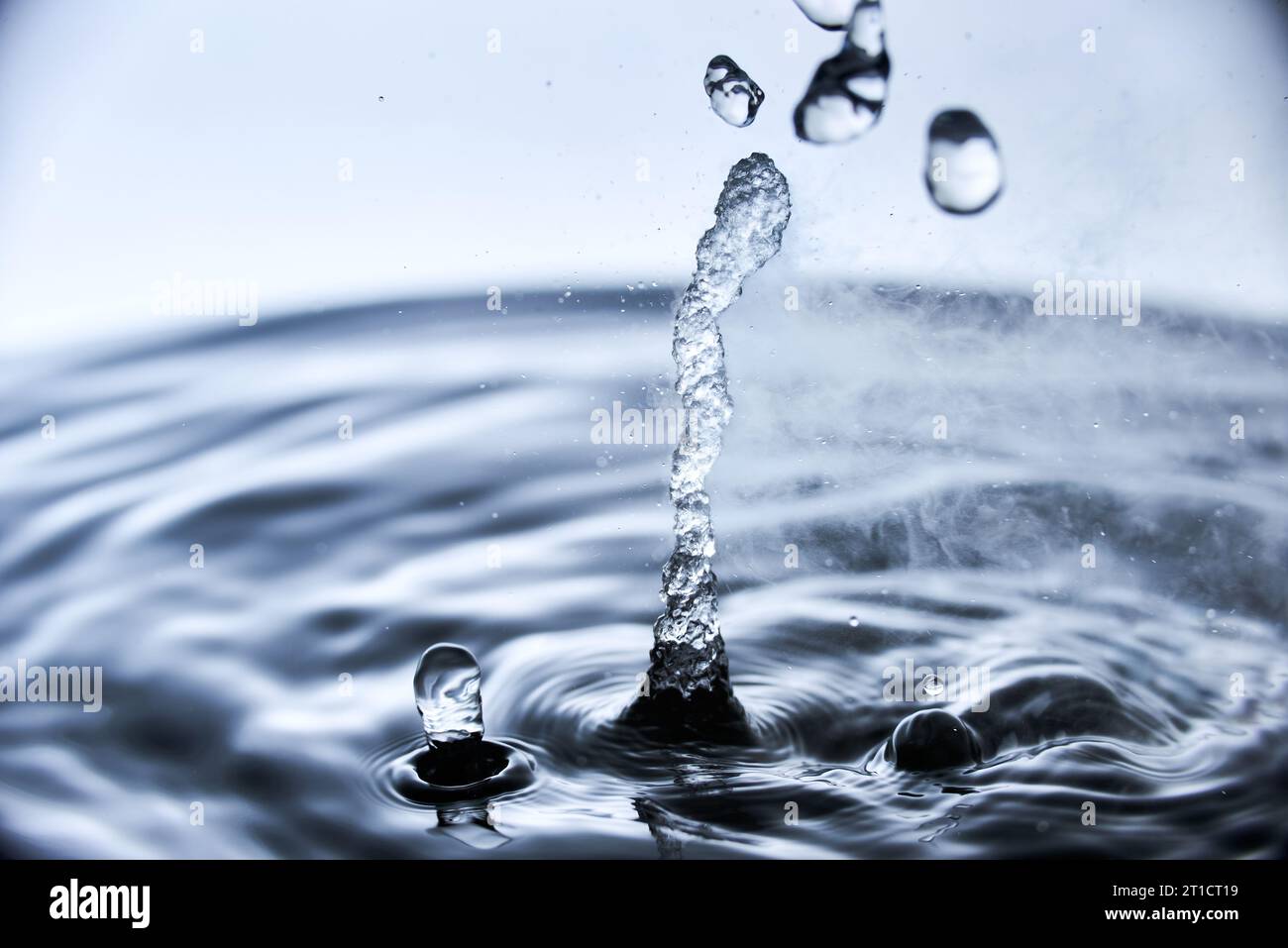 Boiling water splash with steam on blue background closeup Stock Photo ...
