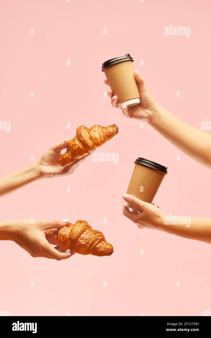Breakfast for two. Human hands holding croissants and coffee cups to go ...