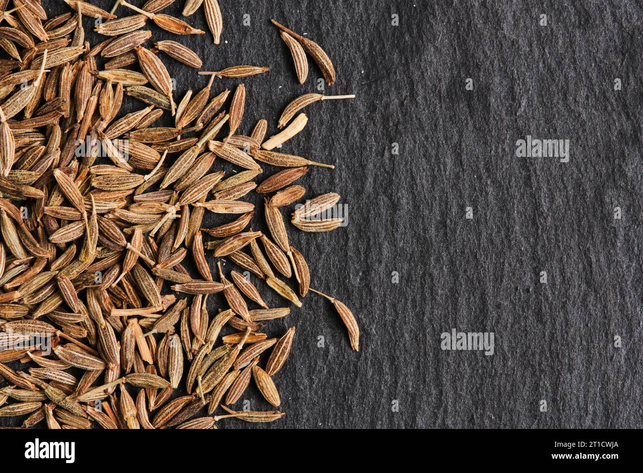 Cumin seeds cumin background slate stone Stock Photo - Alamy