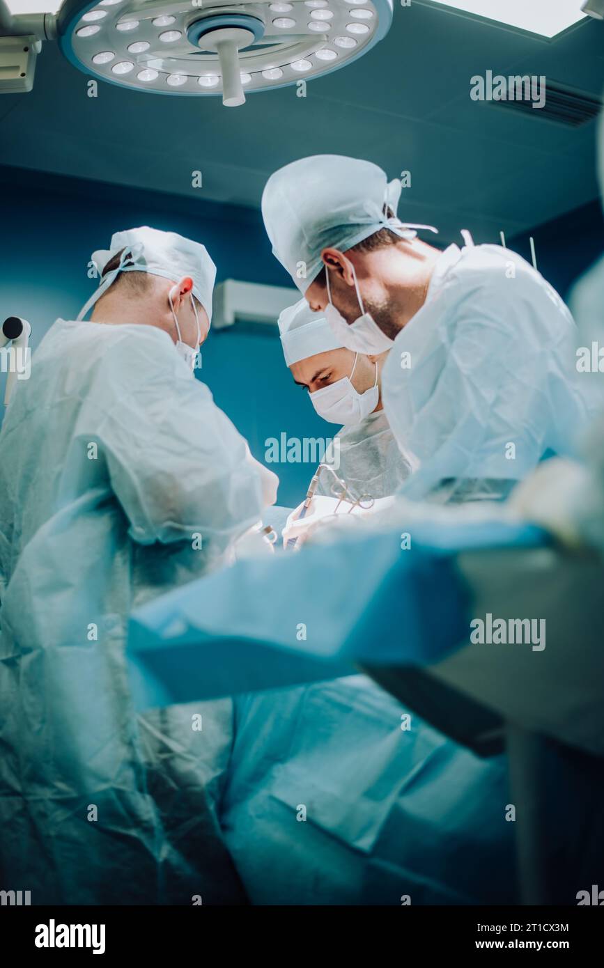 A team of surgeons performs a complex operation to remove a pancreatic ...